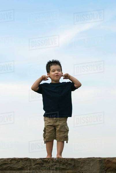 Boy Plugging His Ears - Stock Photo - Dissolve