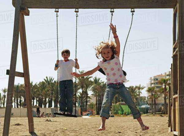 Children Playing On Swing Set - Stock Photo - Dissolve
