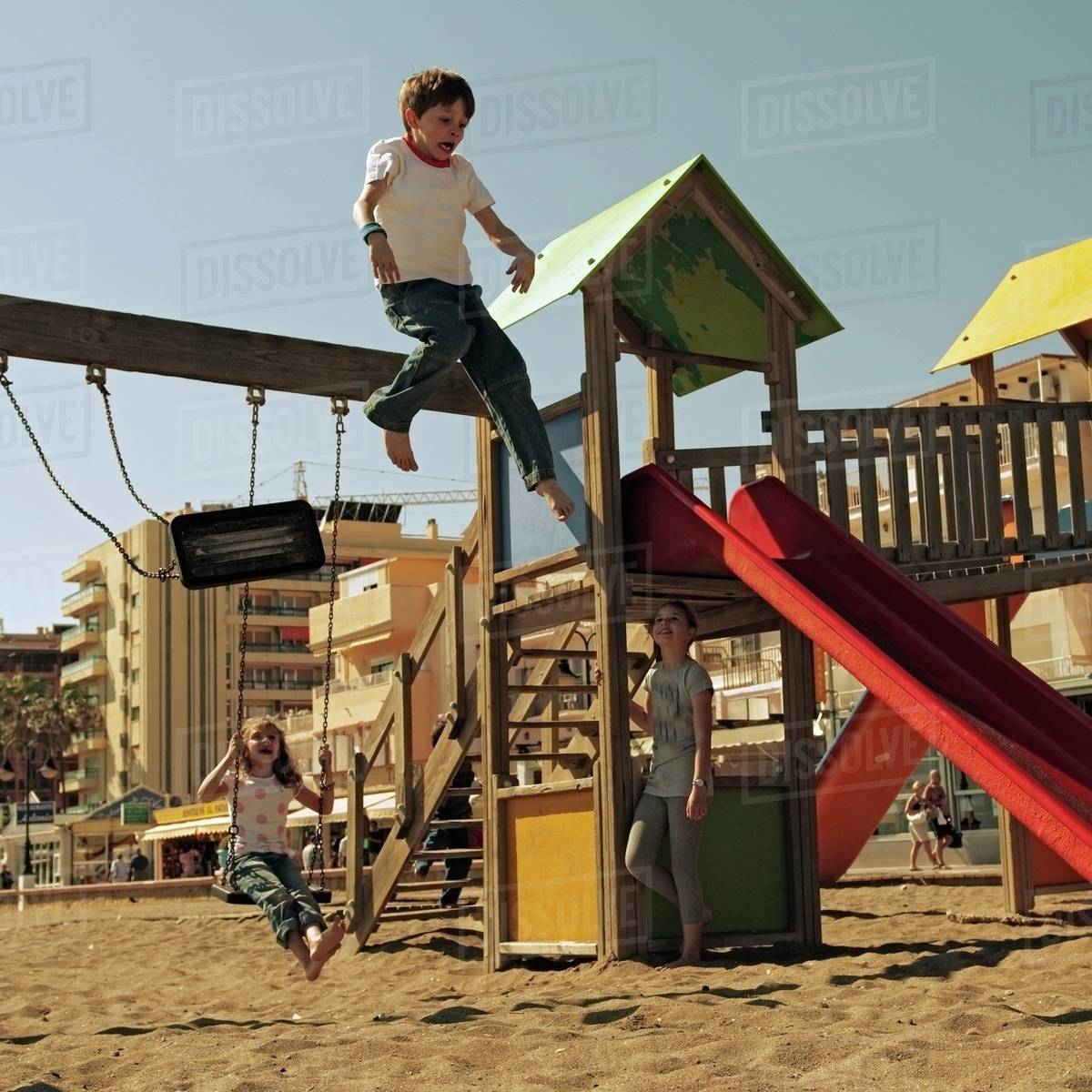 Boy Jumping Off A Swing At The Playground - Stock Photo - Dissolve
