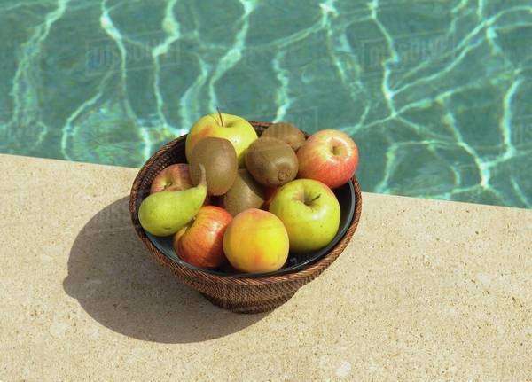 Bowl Of Fruit By A Pool - Stock Photo - Dissolve