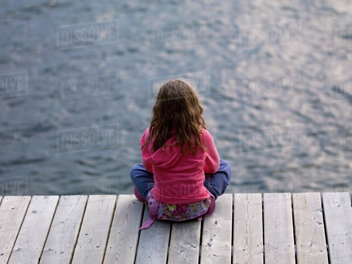Girl Sitting On A Dock - Royalty-free Stock Photo | Dissolve