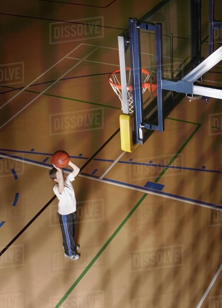 Boy Aiming Ball At Basketball Net - Stock Photo - Dissolve