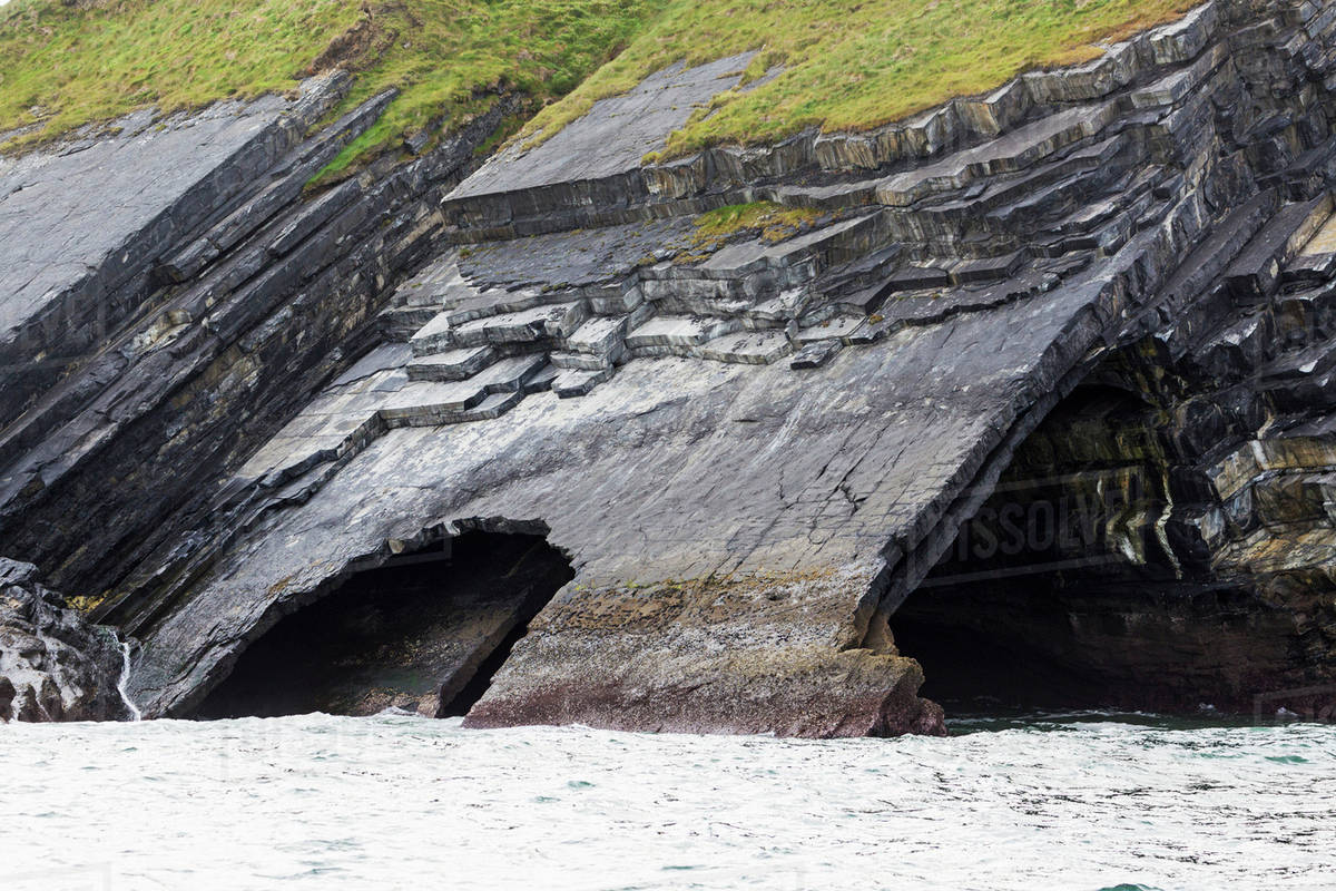 Large rock cave at water's edge in cliff side; Ballybunion, County ...