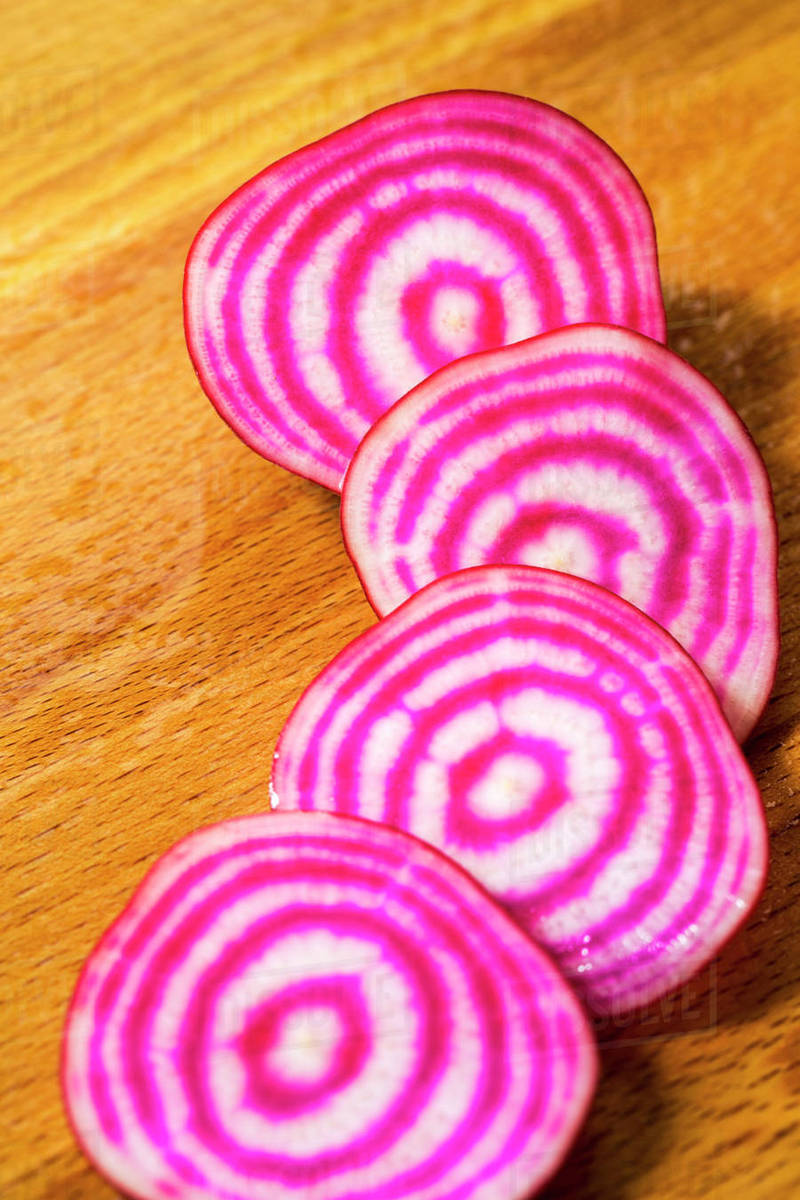 Slices Of Red And White Striped Beets On Wooden Cutting Board; Calgary ...