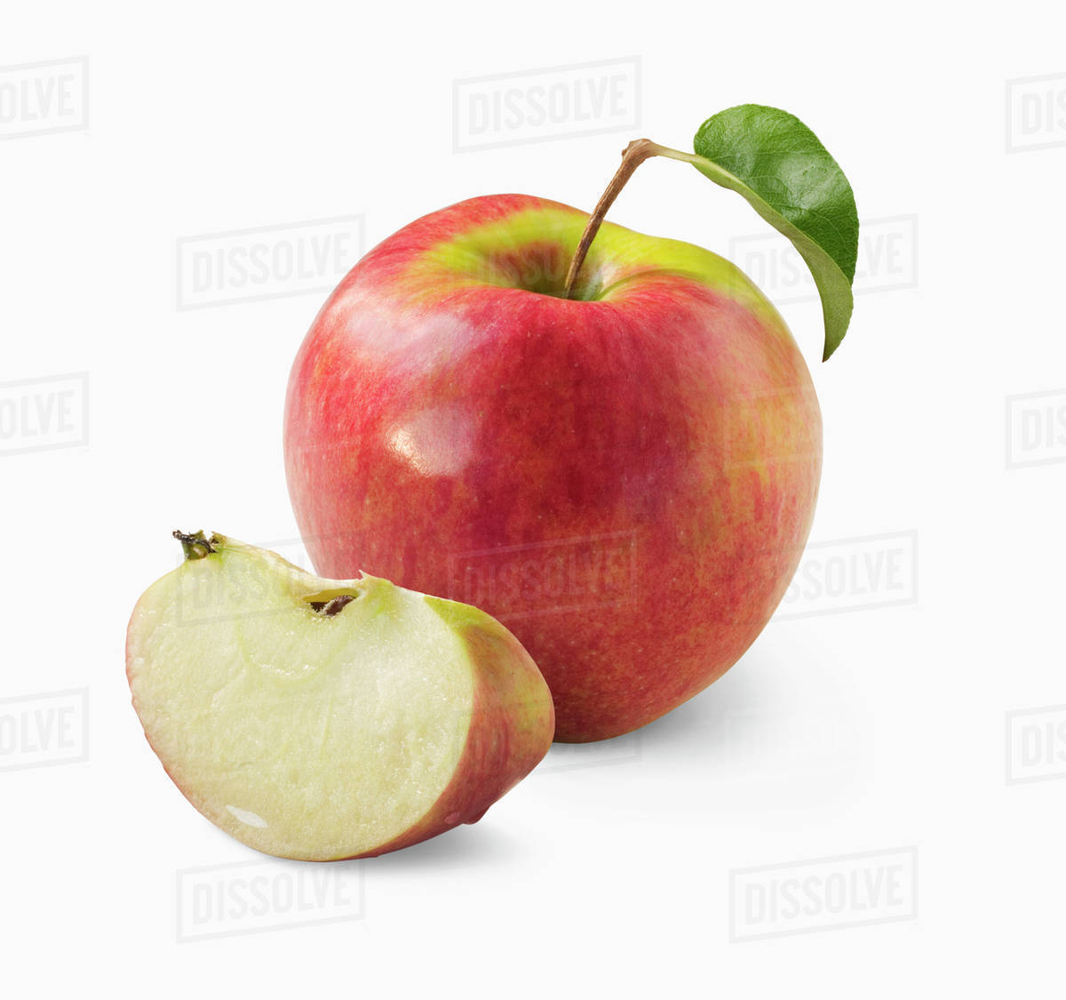 A whole apple with a leaf and a cut slice on a white background ...
