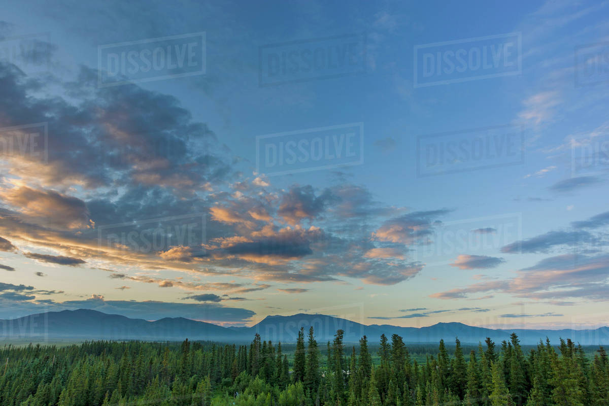 Sun has set over the Baird Mountains, forest and green tundra near the ...