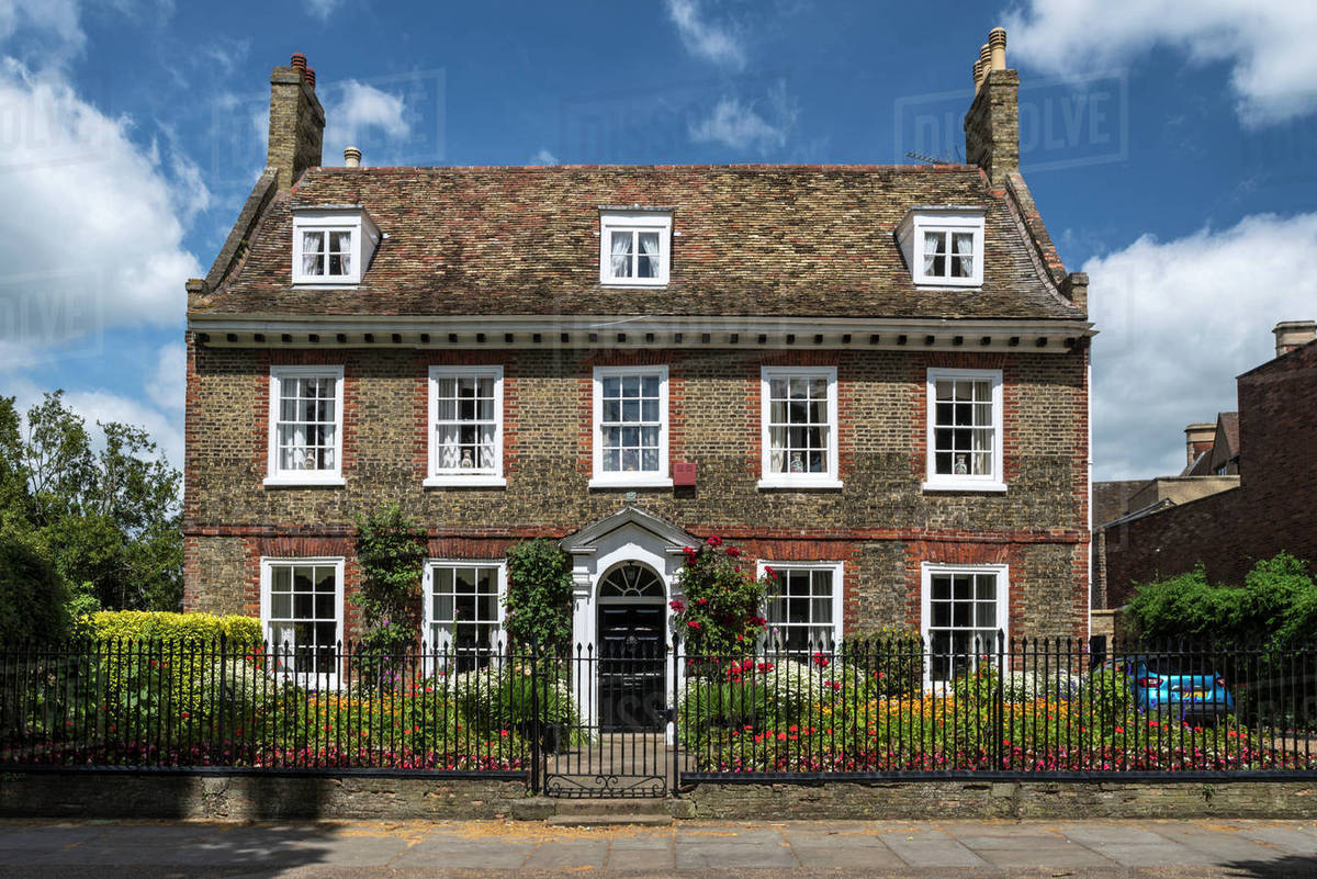 Georgian town house with a wrought iron fence and colourful flower ...