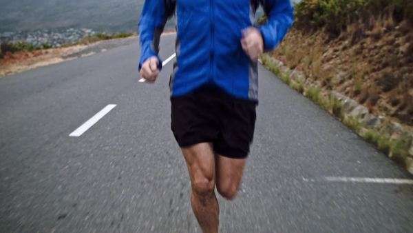 Close-up of man running along road, active healthy lifestyle wellness ...