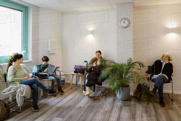 Patients sitting on chair while waiting in clinic - Stock Photo - Dissolve