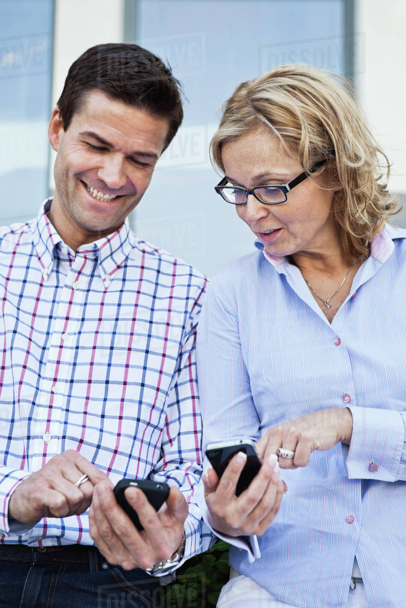 Happy man and woman using mobile phone - Royalty-free Stock Photo ...