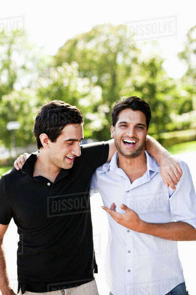 Front view of cheerful male friends with arm around - Royalty-free ...