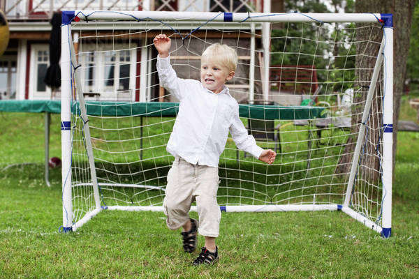 Excited young boy standing at goal post - Royalty-free Stock Photo ...