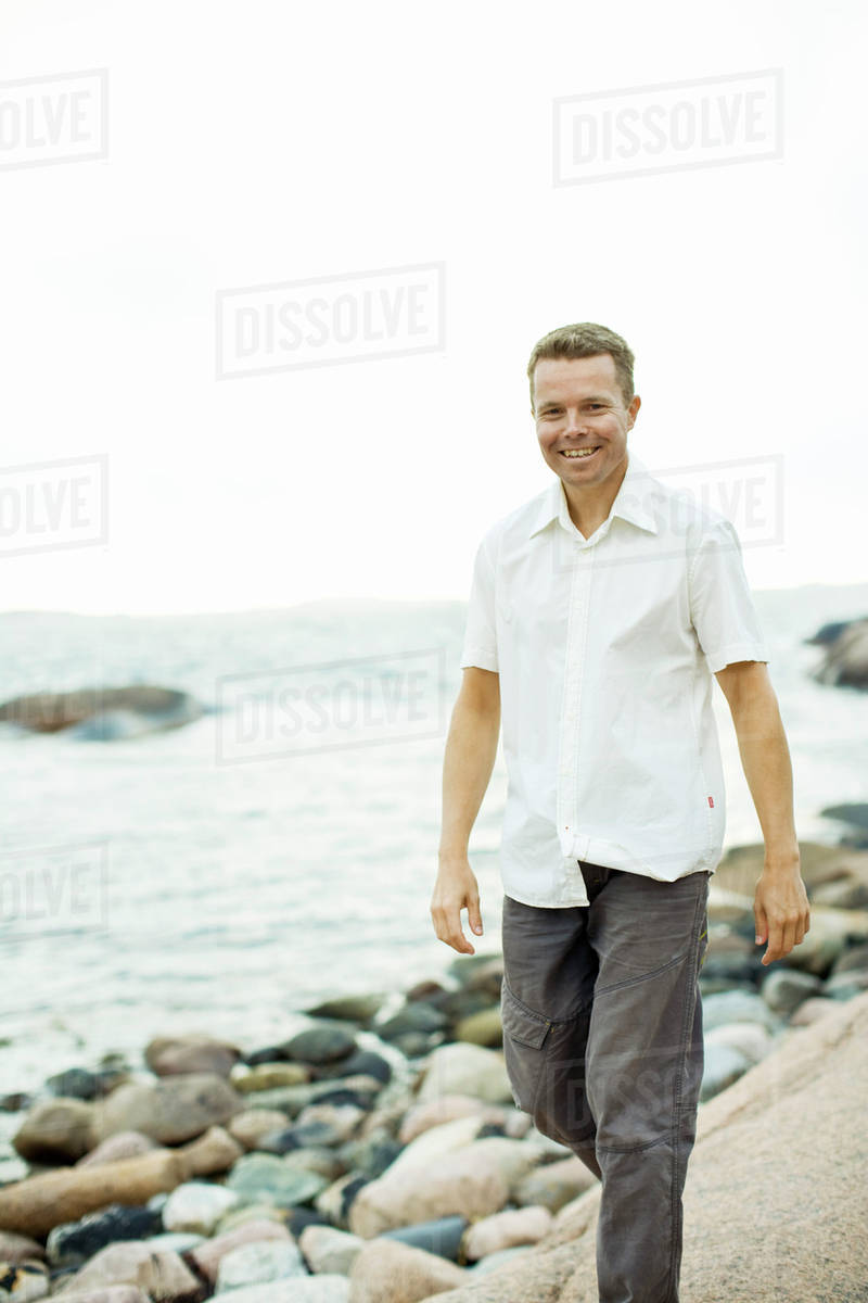 Portrait of a happy man walking on shore - Royalty-free Stock Photo ...