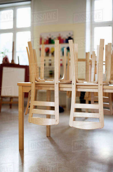 Chairs upside down on table - Royalty-free Stock Photo | Dissolve