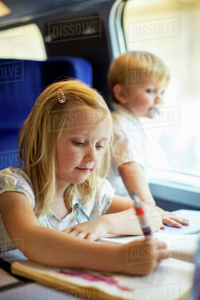 Siblings traveling in train - Stock Photo - Dissolve