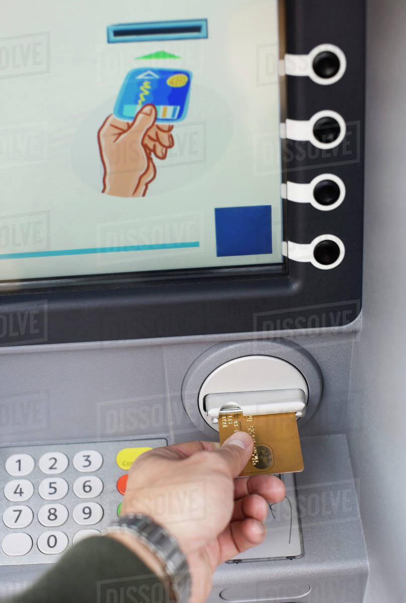 Hand inserting card into ATM - Stock Photo - Dissolve