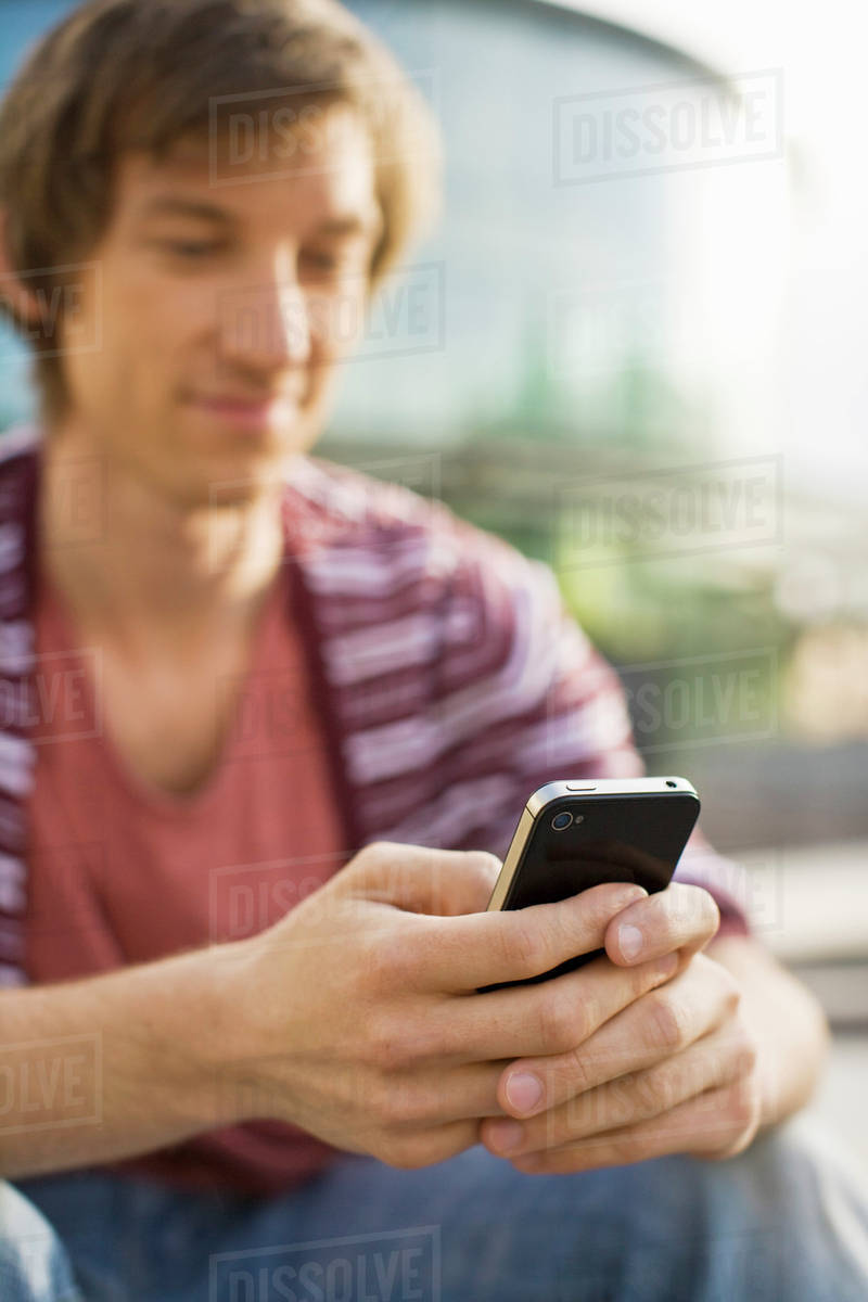 Selective focus of male university student using cell phone - Royalty ...