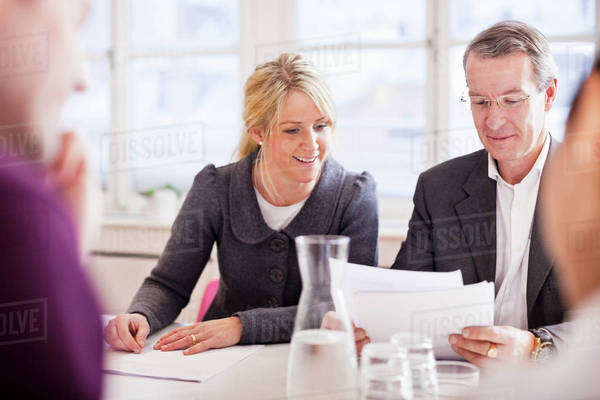 Business people with documents in a meeting - Stock Photo - Dissolve