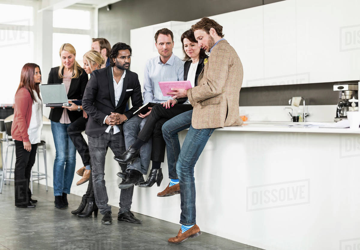 Group of multi-ethnic business people communicating at counter in ...
