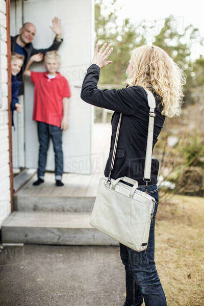 Woman waving goodbye to family - Royalty-free Stock Photo | Dissolve