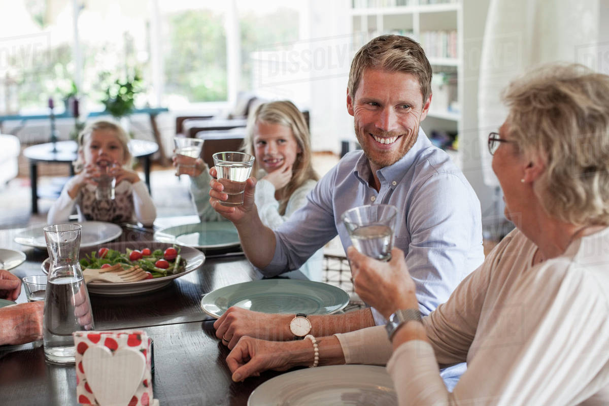 Happy family having lunch together at home - Stock Photo - Dissolve