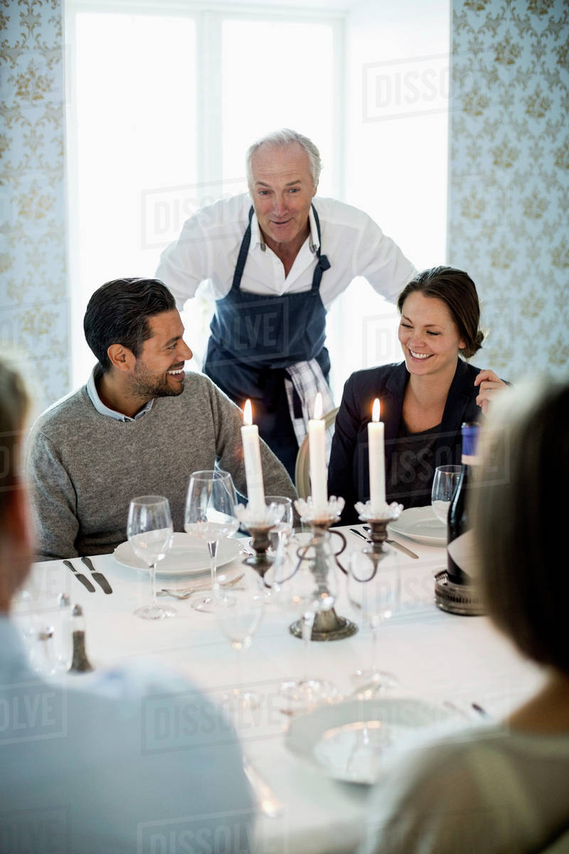 Senior chef talking to business people at dining table in restaurant ...