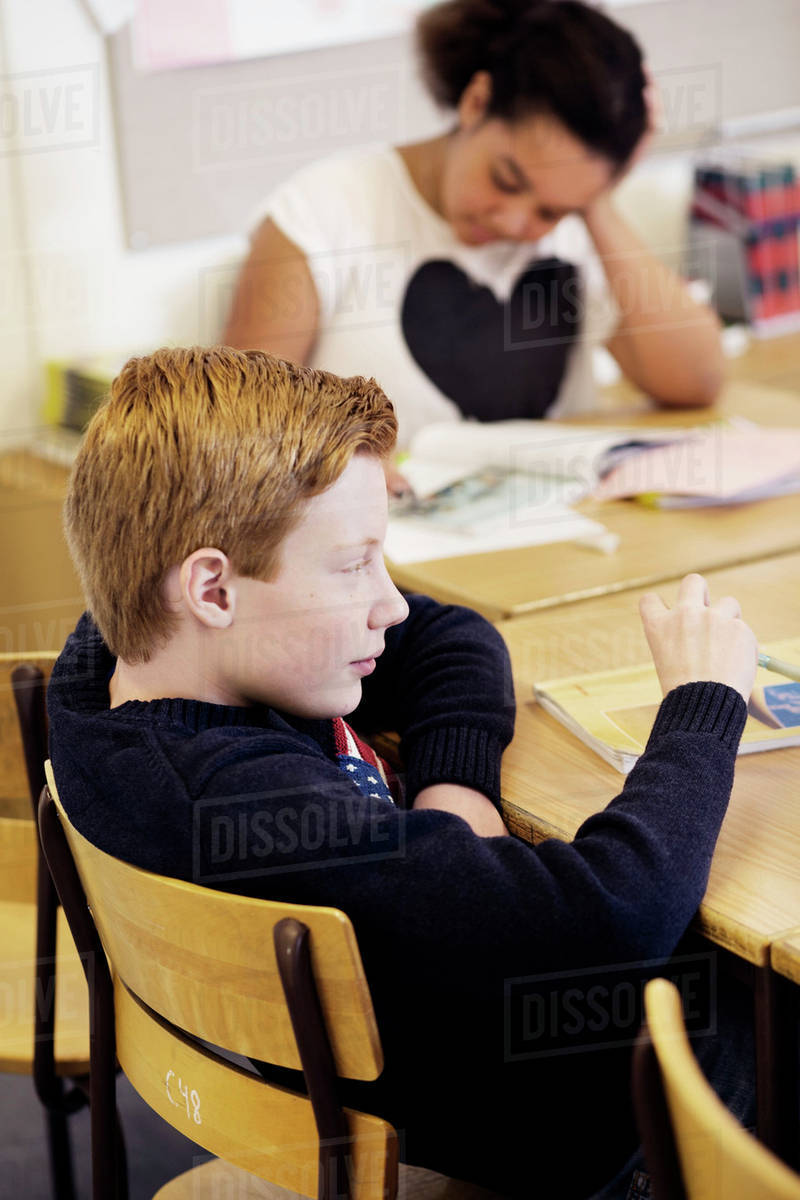 School students sitting at desk in classroom - Royalty-free Stock Photo ...