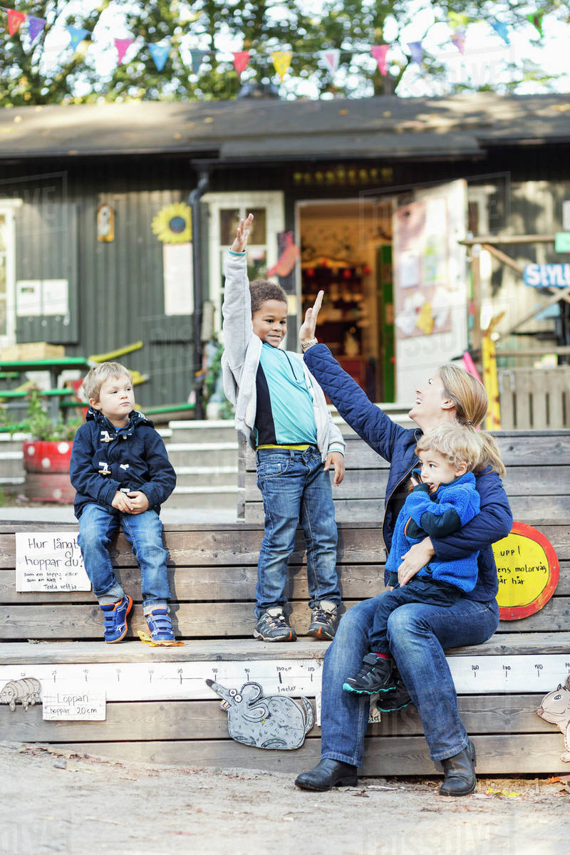 Happy teacher giving high-five outside preschool building - Stock Photo ... Happy teacher giving high-five outside preschool building - Stock Photo ...