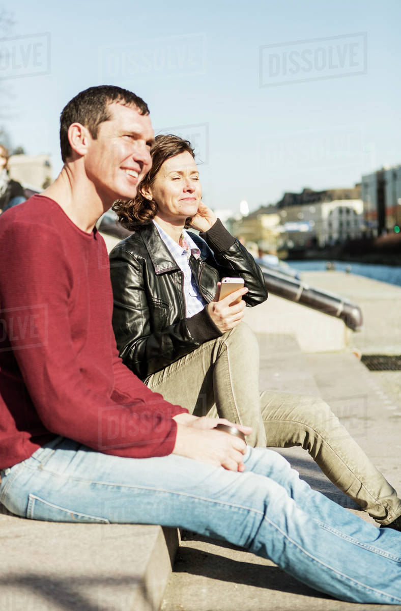 Thoughtful business people sitting on steps outdoors - Royalty-free ...