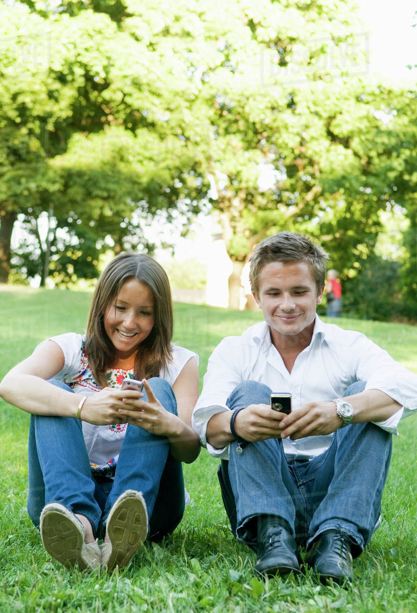 Happy sibblings with cellphones - Royalty-free Stock Photo | Dissolve