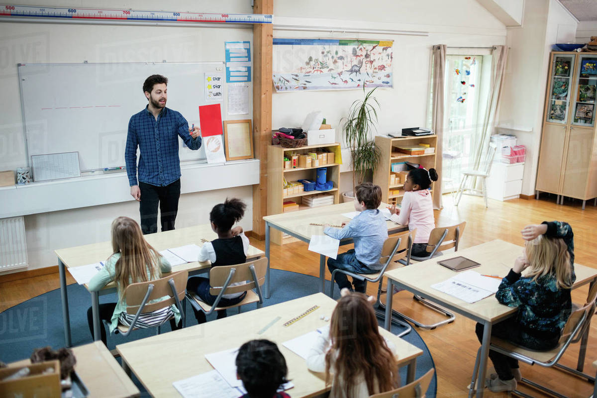 High angle view of teacher teaching students in classroom at school ...