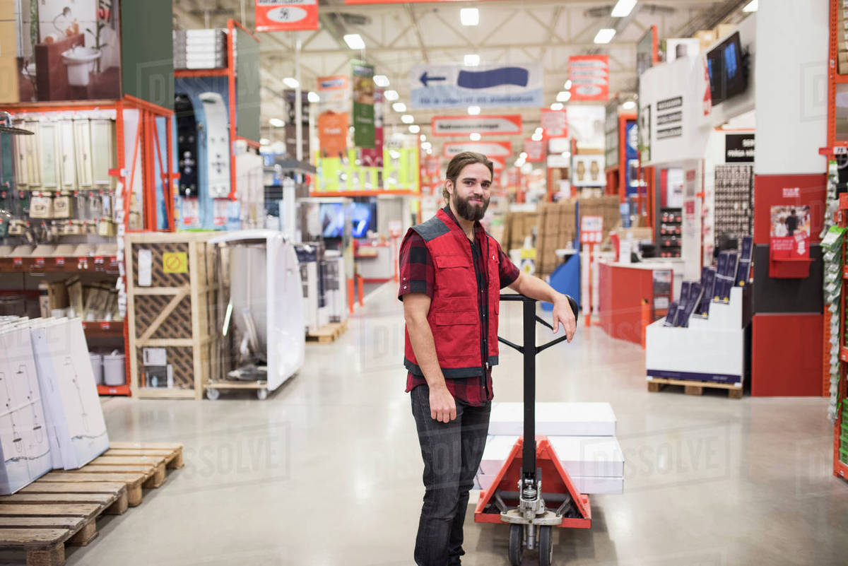 Portrait of salesman standing by handtruck in hardware store - Royalty ...