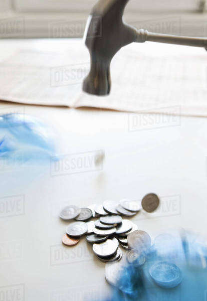 Hammer hitting coins - Royalty-free Stock Photo | Dissolve