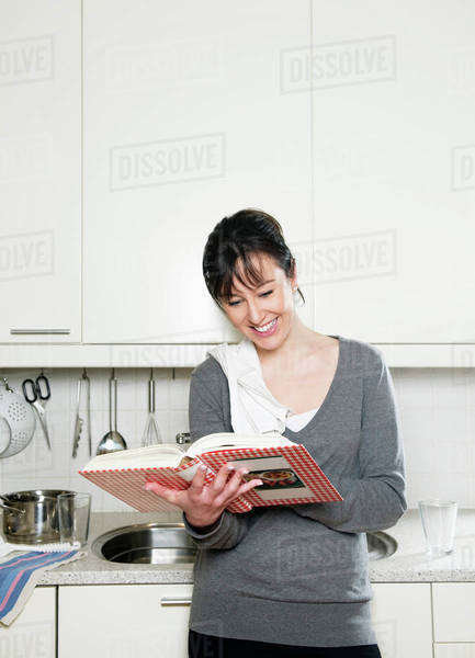 Woman with cookbook - Stock Photo - Dissolve