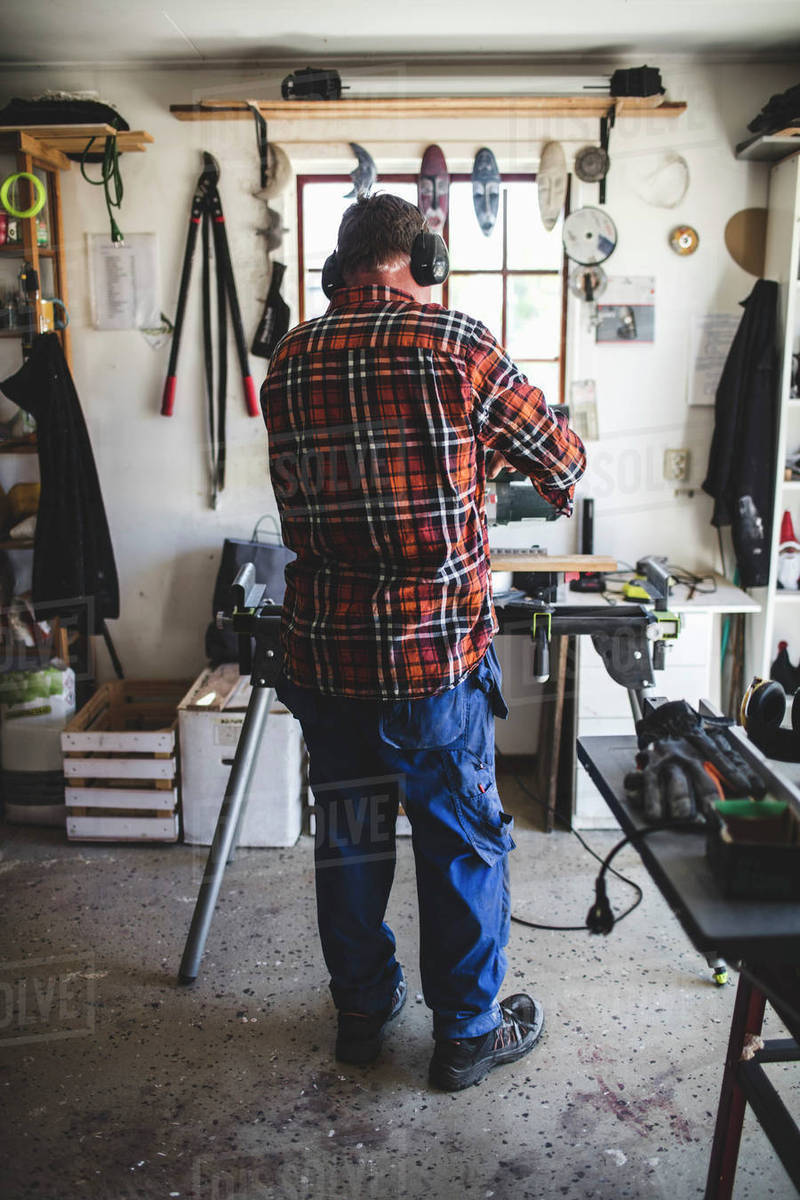 Full length rear view of senior man working in workshop - Stock Photo ...