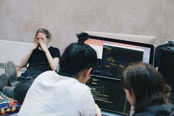 Male and female computer programmers using computer at office - Royalty ...