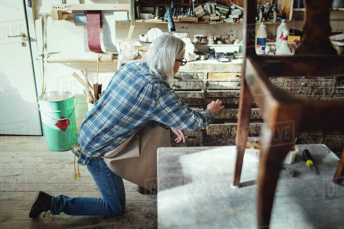 Full length of senior female craftsperson working at workshop - Royalty ...