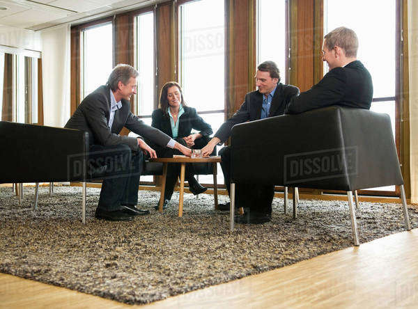 Four people sitting in armchairs - Royalty-free Stock Photo | Dissolve