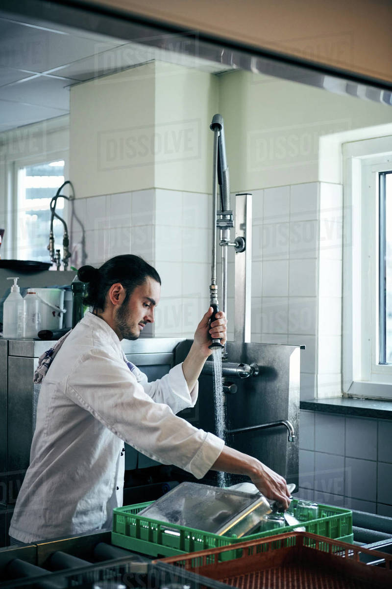 Side view of chef washing dishes in kitchen - Royalty-free Stock Photo ...