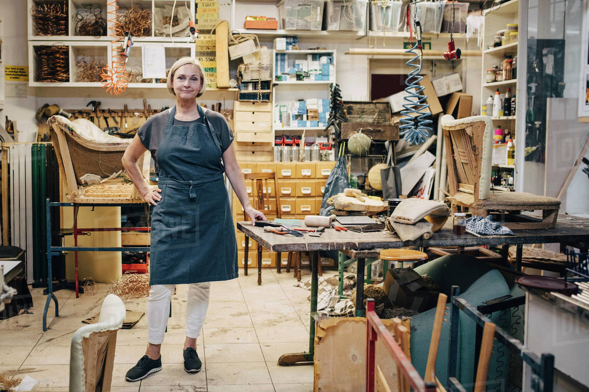 Portrait of female craftsperson standing in upholstery workshop ...