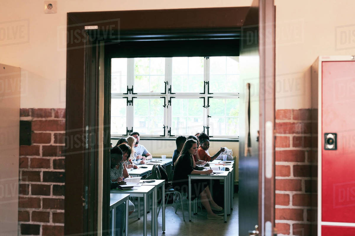 Students learning language in classroom seen through doorway - Royalty ...