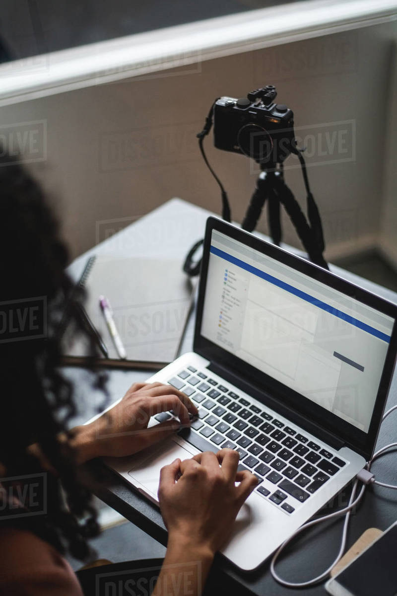 High angle view of young female influencer vlogging while using laptop ...