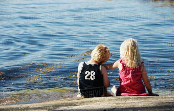 Boy and girl on rock - Stock Photo - Dissolve