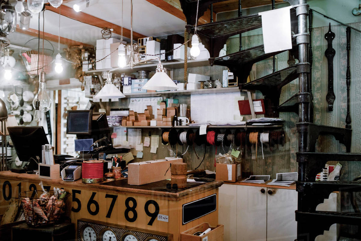 Illuminated pendant lights hanging over checkout counter against ...