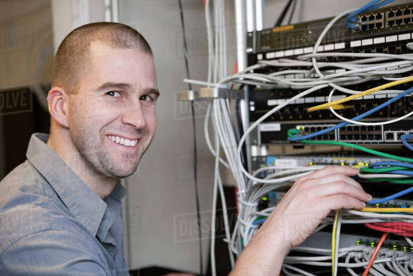 Happy man fixing network cables - Royalty-free Stock Photo | Dissolve