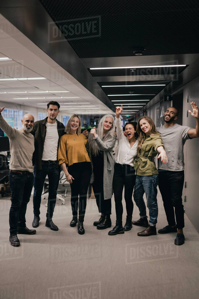 Portrait of business team cheering while standing together at open ...