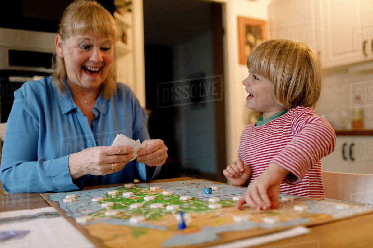 Cheerful grandmother and grandson playing board game at home - Royalty ...
