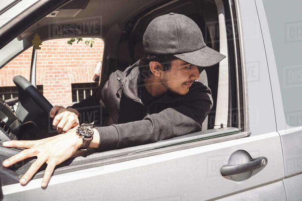 Delivery man looking through window while driving truck - Royalty-free ...