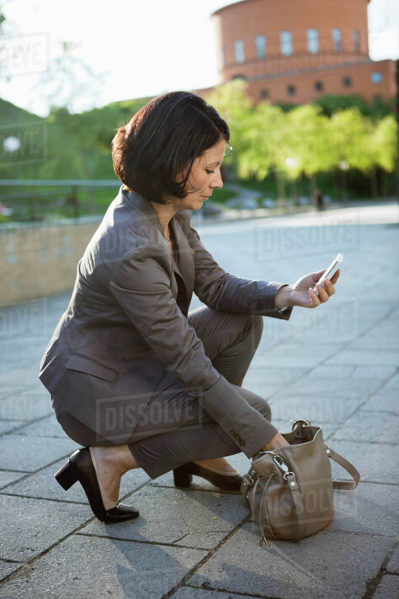 Woman looking in purse - Stock Photo - Dissolve