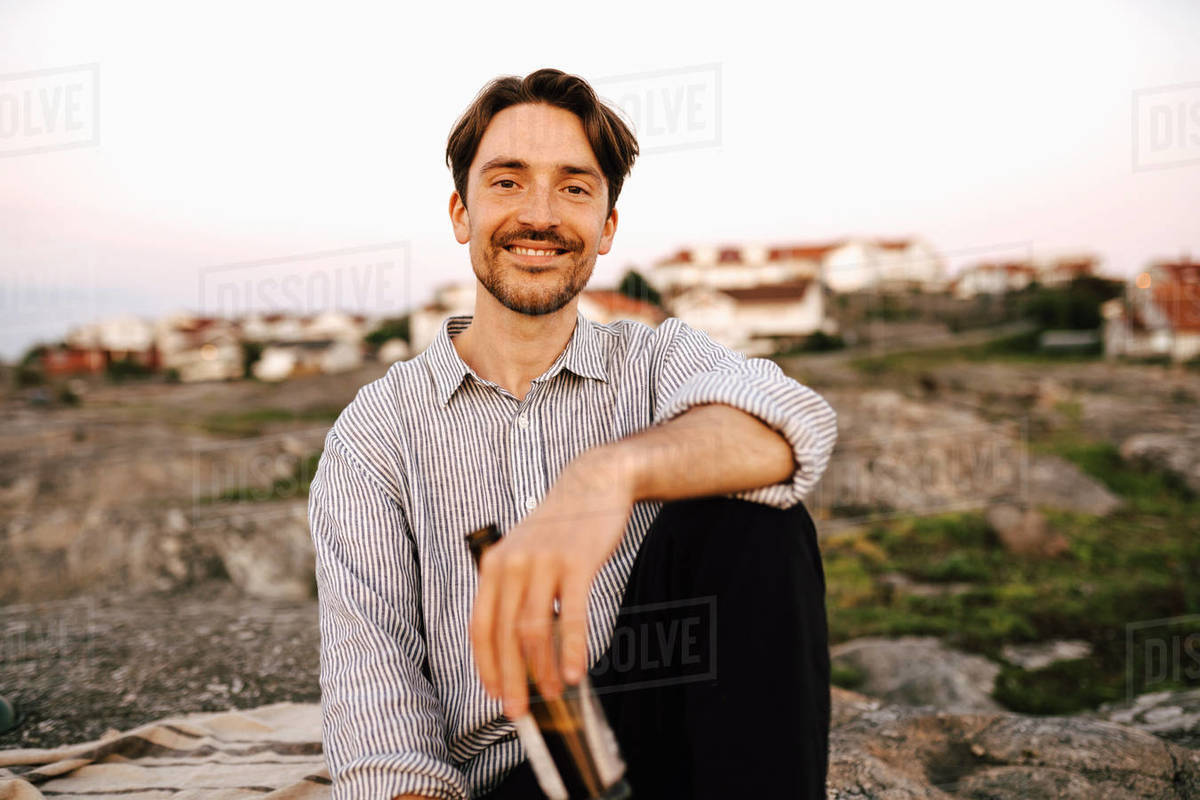 Portrait of smiling man with beer bottle - Royalty-free Stock Photo ...
